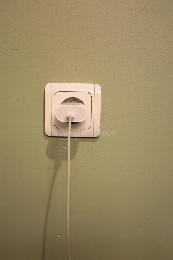 Electrical Outlet with Plug and Charger on Green Wall Stock Image ...