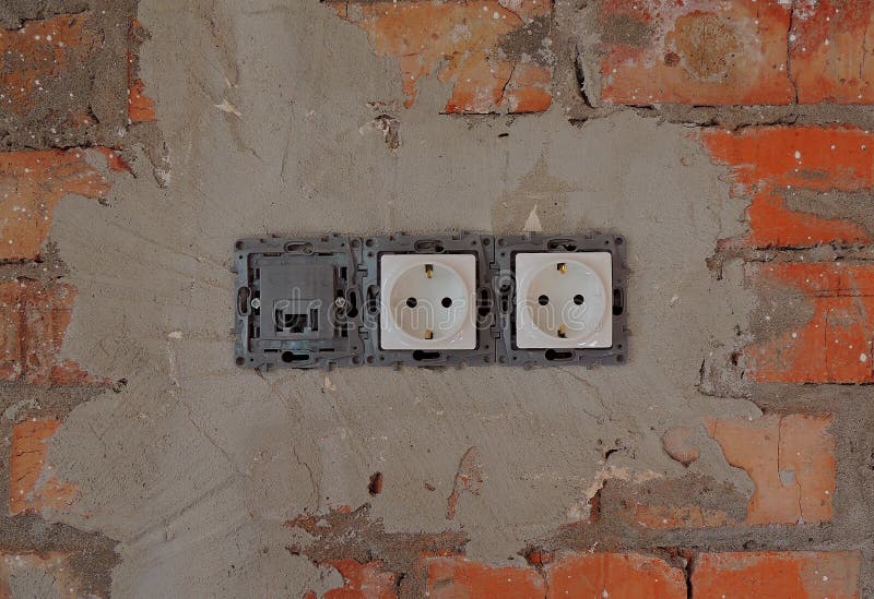 Installation of the Electrical Outlet Plug in the Brick Wall Stock ...