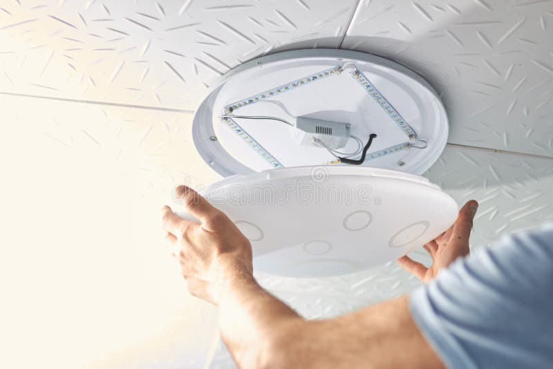 An Electrical Technician Changes a Low-consumption LED Lamp into a ...