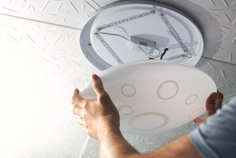 An Electrical Technician Changes a Low-consumption LED Lamp into a ...