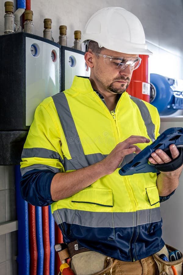 Man, an Electrical Technician Working in a Switchboard with Fuses ...