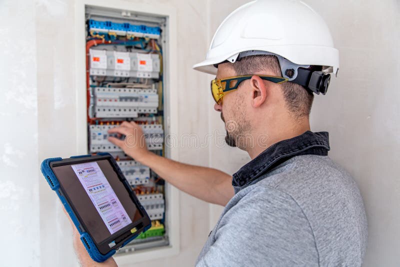 Electrical Technician Looking Focused while Working in a Switchboard ...