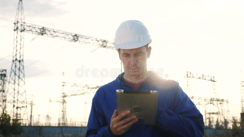 Electrical Worker Engineer a Working with Digital Power Tablet, Near ...