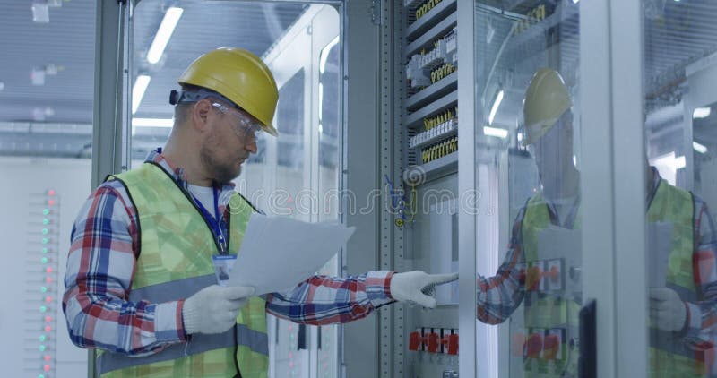 Electrical Worker Reading Paperwork and Inspecting Equipment Stock ...
