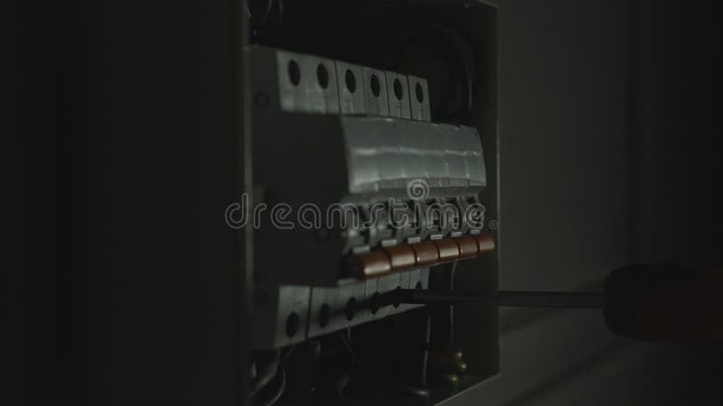 Electrician Assembles Electrical Panel in the Dark. Close Up of a ...
