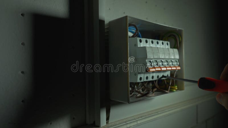 Electrician Assembles Electrical Panel in Dark by Light of Flashlight ...
