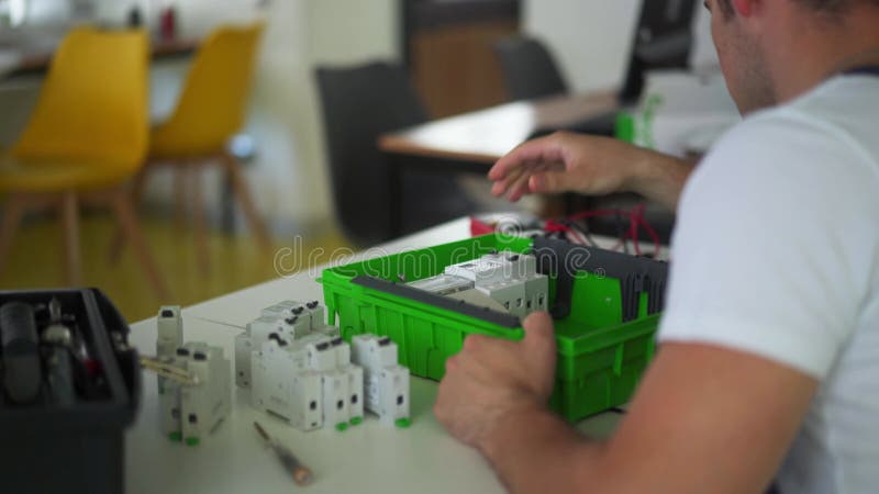 Electrician Assembles Electrical Panel Fuse Box in Workshop. Worker ...