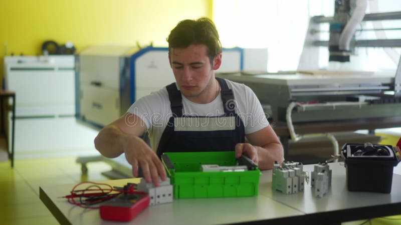 Electrician Assembles Electrical Panel Fuse Box in Workshop. Worker ...
