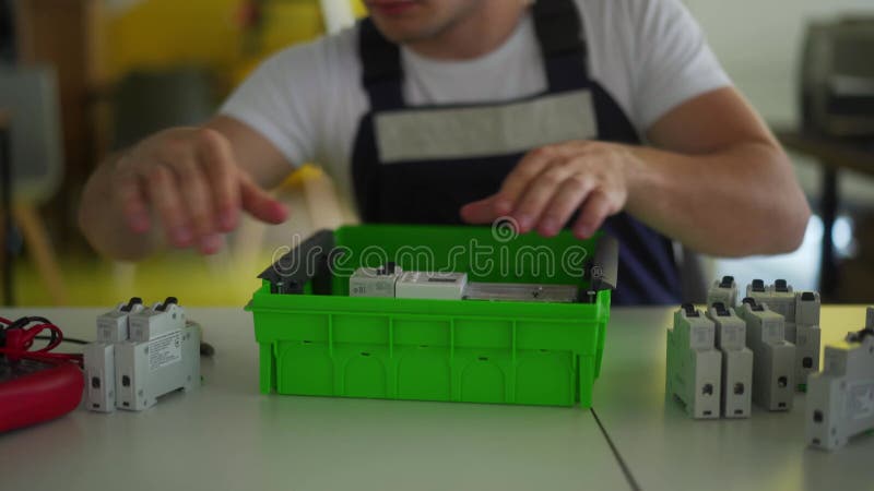Electrician Assembles Electrical Panel Fuse Box in Workshop. Worker ...
