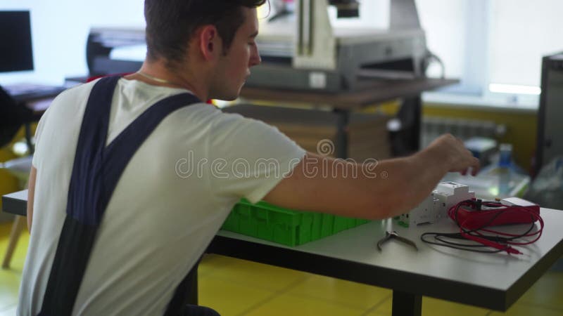 Electrician Assembles Electrical Panel Fuse Box in Workshop. Worker ...