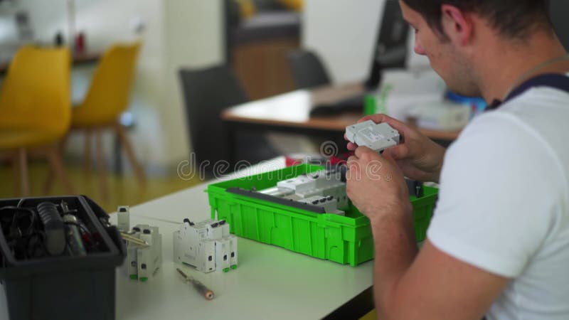 Electrician Assembles Electrical Panel Fuse Box in Workshop. Worker ...