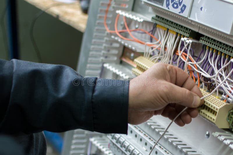 Electrician Assembling Industrial HVAC Control Panel in Workshop. Close ...