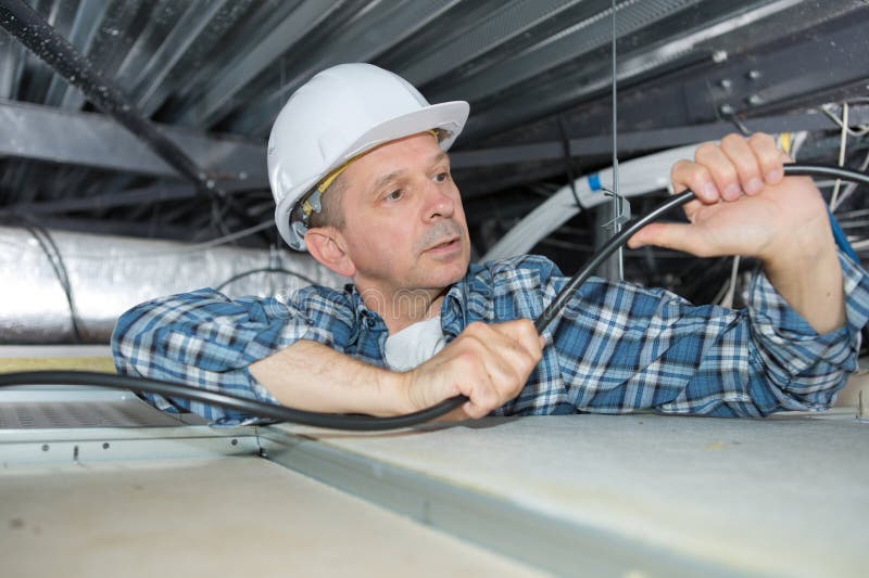 Electrician Bending Cable in Roof Space Stock Photo - Image of energy ...