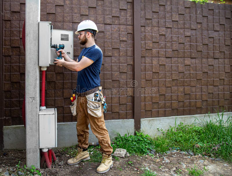 Electrician Builder at Work, Examines the Cable Connection in the ...