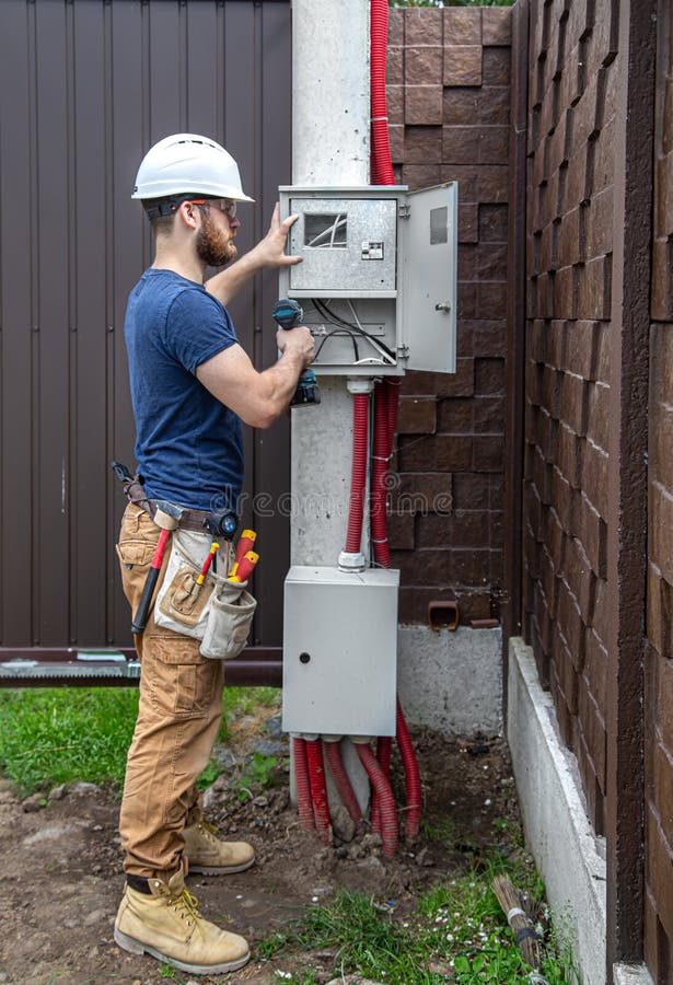 Electrician Builder at Work, Examines the Cable Connection in the ...