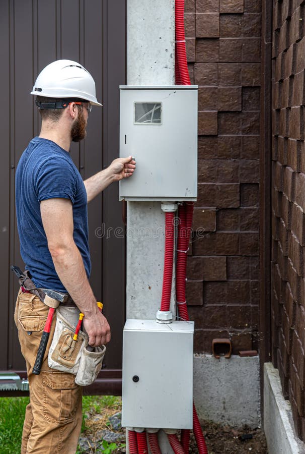 Electrician Builder at Work, Examines the Cable Connection in the ...