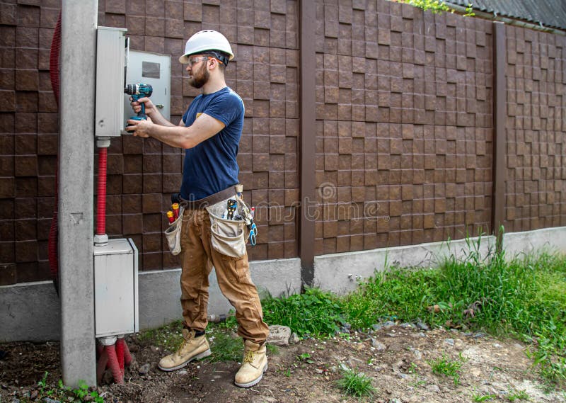 Electrician Builder at Work, Examines the Cable Connection in the ...