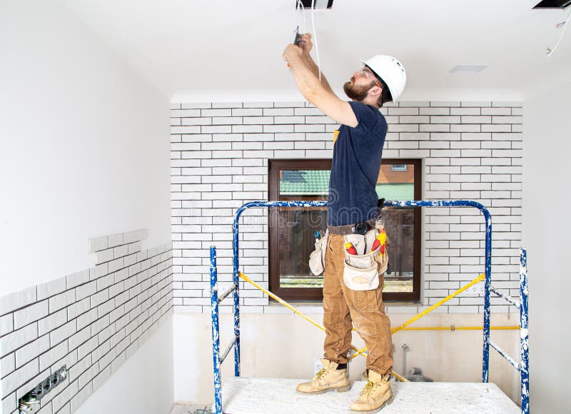 Electrician Builder at Work, Installation of Lamps at Height ...