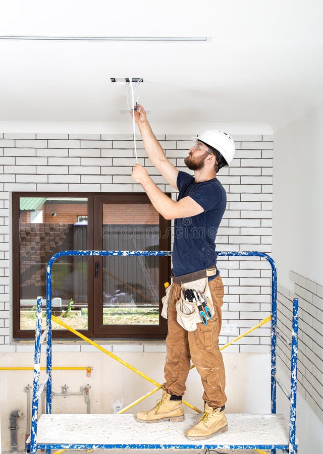 Electrician Builder at Work, Installation of Lamps at Height ...