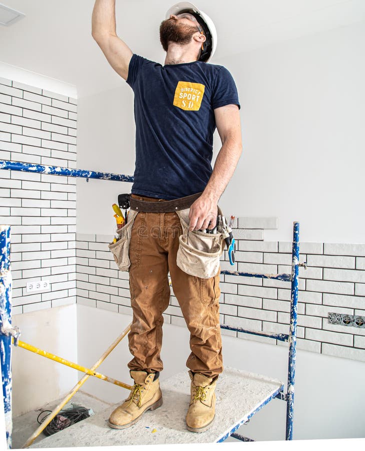 Electrician Builder at Work, Installation of Lamps at Height ...