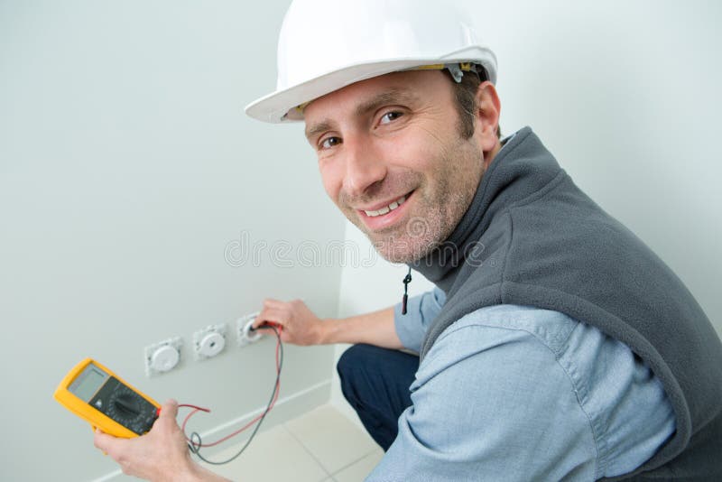 Electrician Checking Voltage in Partially Installed Electrical Wall ...