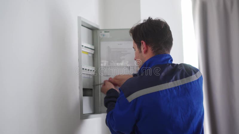 Electrician Disassembles Electrical Fuse Box. Master in Uniform ...