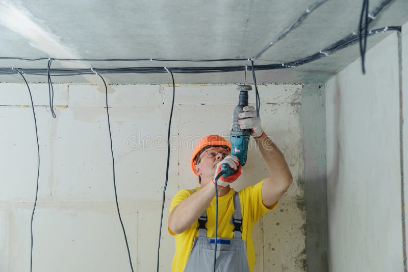 An Electrician is Drilling a Ceiling with a Perforator. Stock Image ...