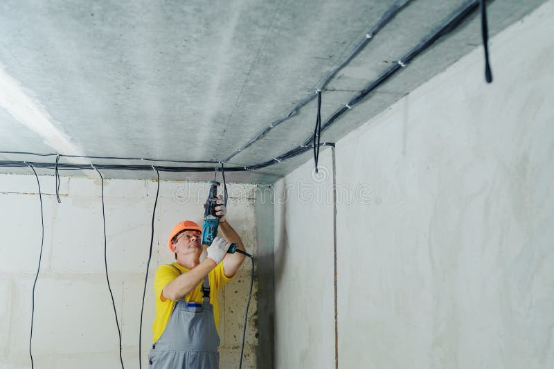 An Electrician is Drilling a Ceiling with a Perforator. Stock Photo ...