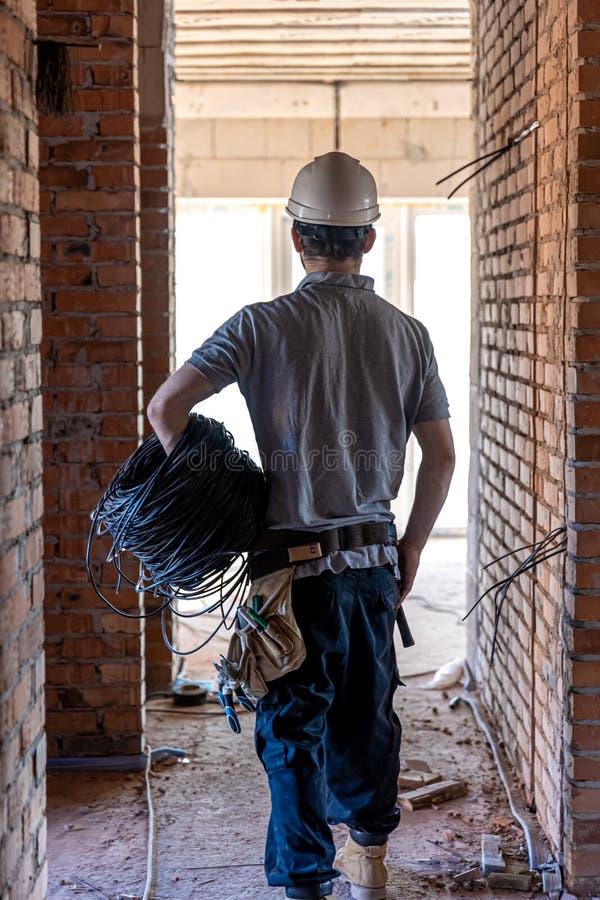 An Electrician Contractor Examines a Blueprint at a Construction Site ...