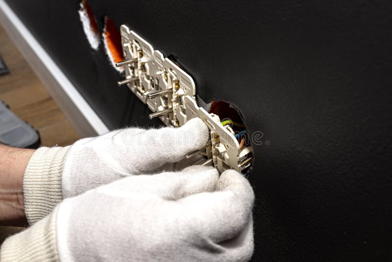 An Electrician Inserts a Double Grounded Electrical Socket into an ...