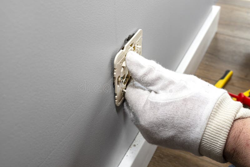 An Electrician Inserts a Double Grounded Electrical Socket into an ...