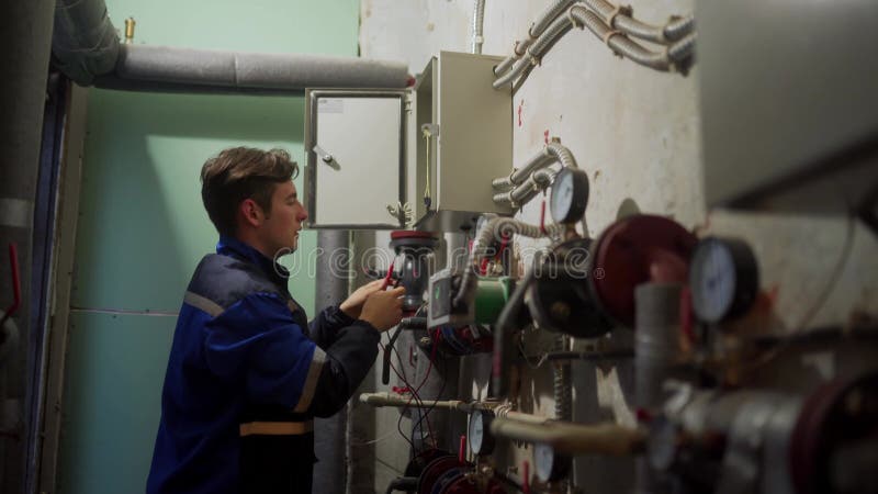 Electrician Inspecting Electrical Fuse Box. Master in Uniform Screwing ...