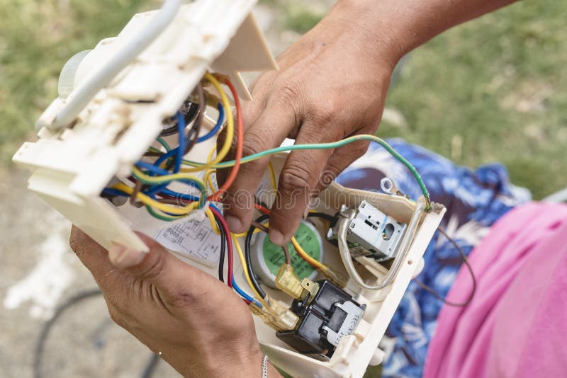 An Electrician Inspects the Control Panel of a Window Type Air ...