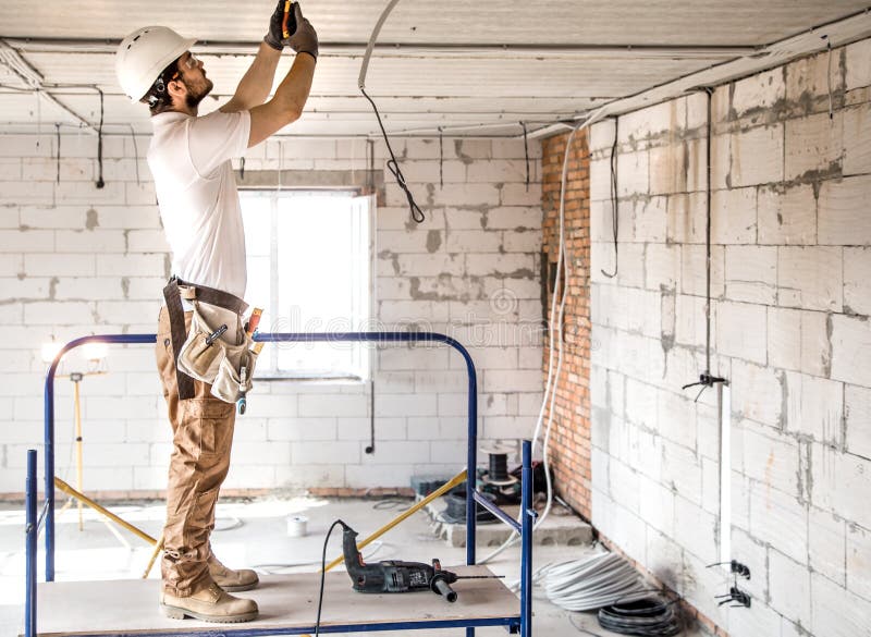 Electrician Installer with a Tool in His Hands, Working with Cable on ...