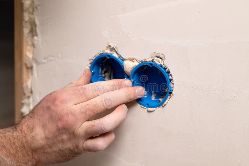 Electrician Installing Blue Socket Boxes into a Plastered Wall during ...