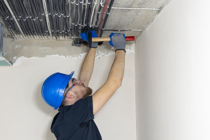 Electrician Installing Laying Electrical Cables on the Ceiling Inside ...