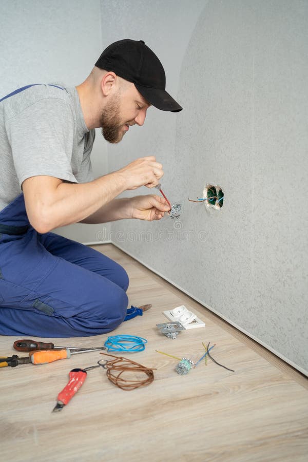 Electrician Installing Wall Socket on the White Wall Indoors Stock ...