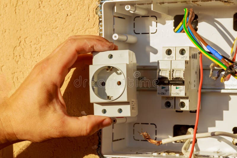 The Electrician Installs the Socket into the Electrical Panel. Stock ...