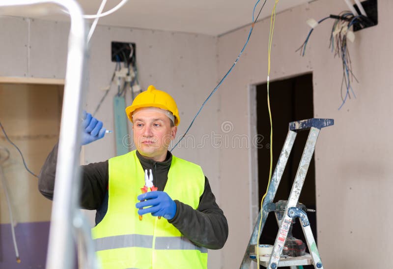 Electrician Laying Electric Wires in Building Under Construction Stock ...
