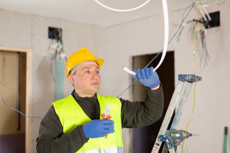 Electrician Laying Electric Wires in Building Under Construction Stock ...