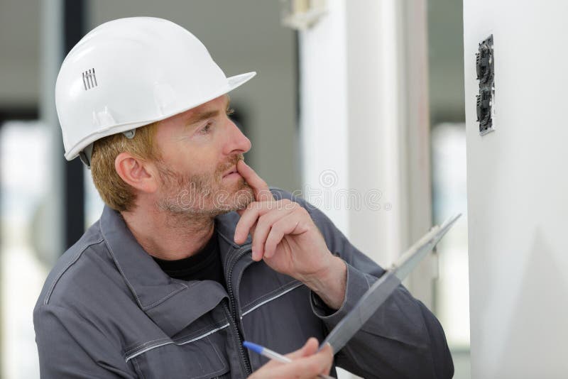 Electrician Looking at Socket on Wall Stock Photo - Image of supply ...