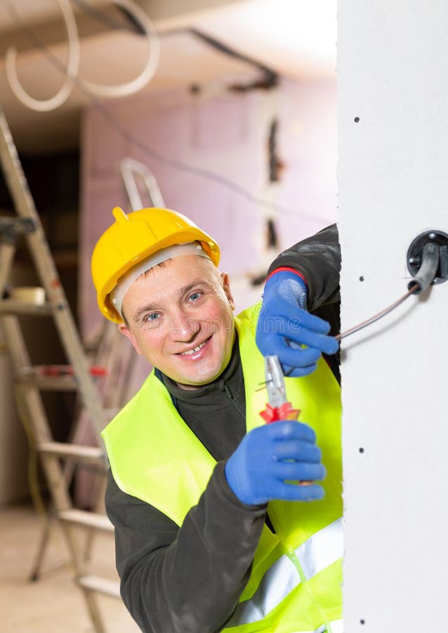 Electrician Mounting Electrical Wiring Inside Building in Process of ...