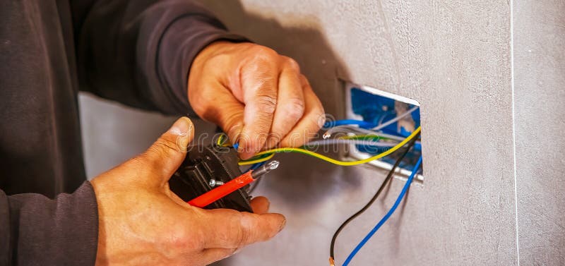 Electrician Mounts an Electrical Outlet To the Wall, Connecting Cables ...