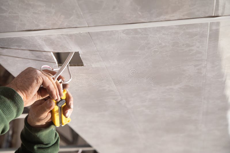 Electrician Performs Electric Installation on the Ceiling of a House ...