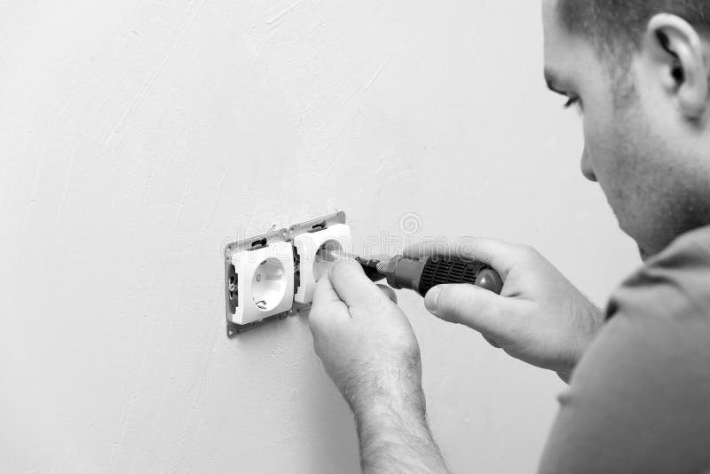 Electrician Repairing Electrical Socket on White Wall Stock Photo ...