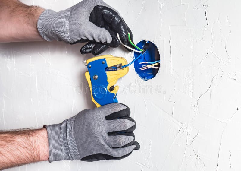 The Electrician`s Hands with a Special Tool Clean the Wires in a ...