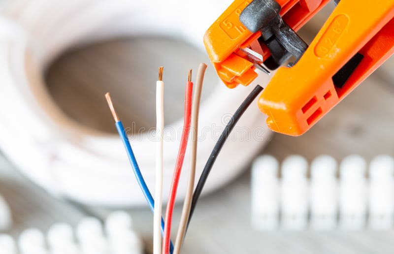 Electrician is Stripping Electrical Wires in a Plastic Box on a Wooden ...