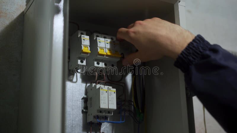 Electrician Switches on the Breakers in a Fuse Box, Master Powers on ...