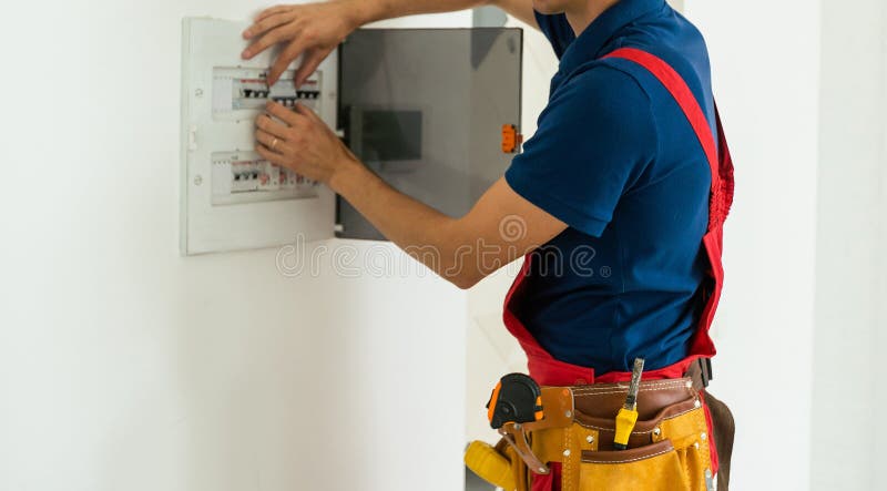 Electrician Technician with Screwdriver Fastens the Cable in a ...