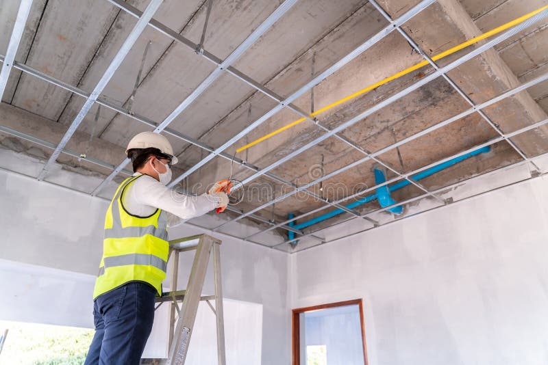 Electrician Wearing a Mask Installing Laying Electrical Cables on the ...